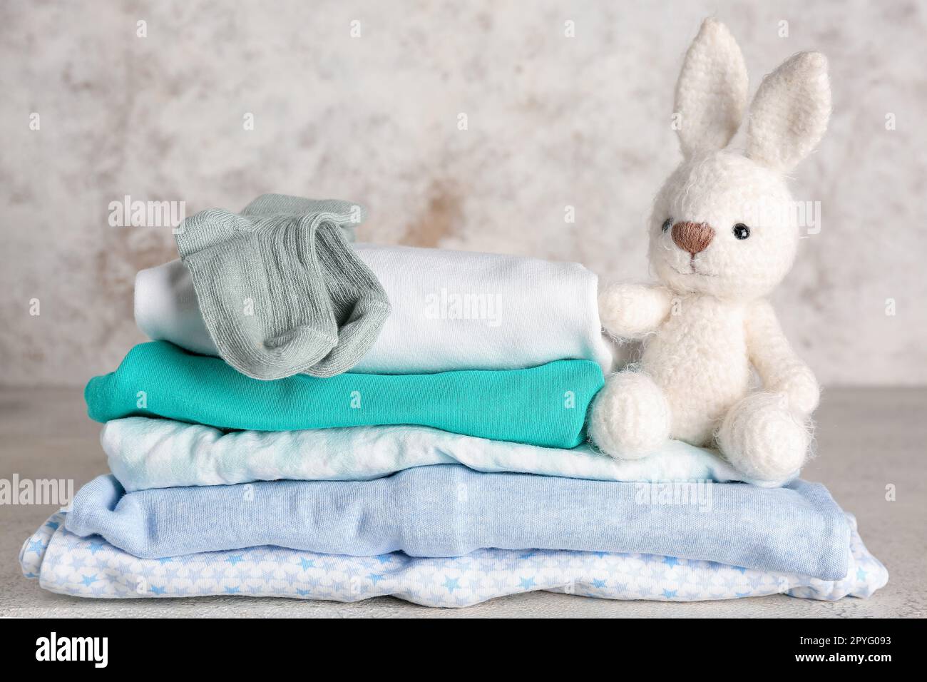 Stack of baby clothes and toy bunny on light background Stock Photo - Alamy