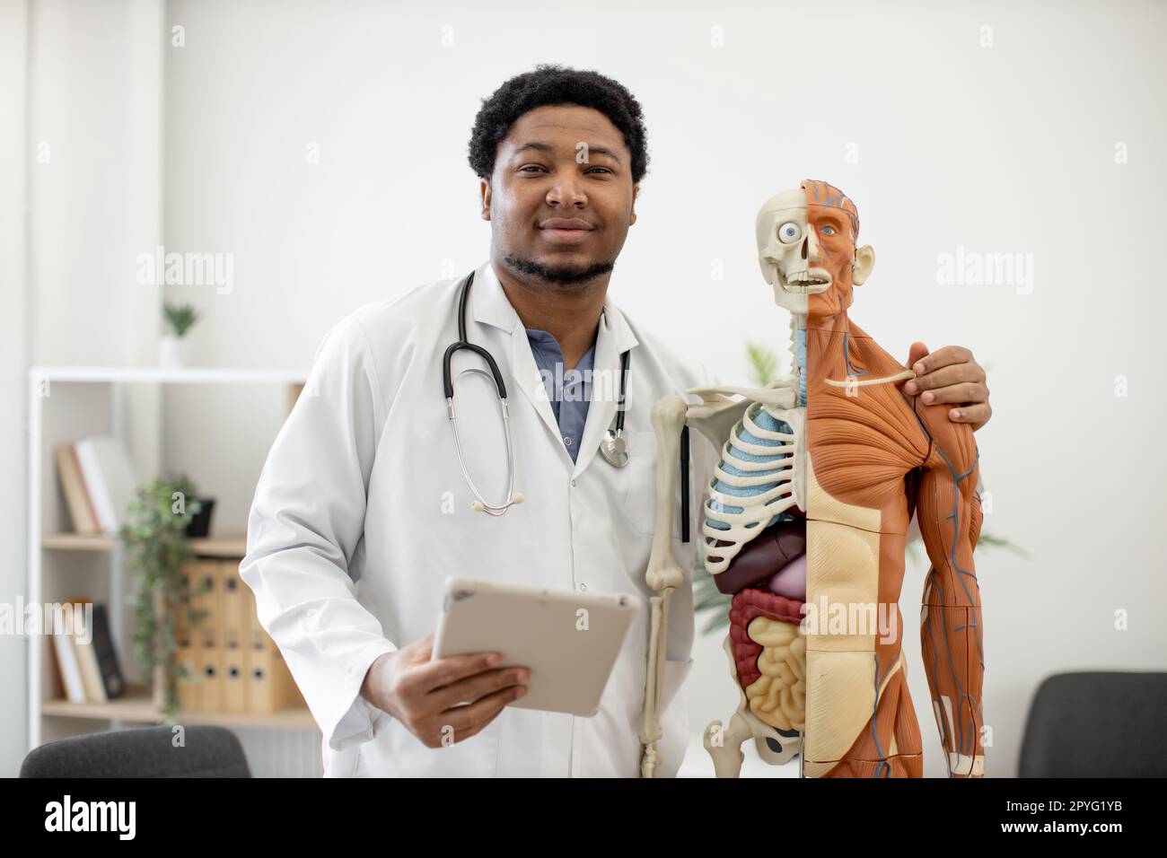Smiling multicultural male adult in lab wearing lab coat and ...