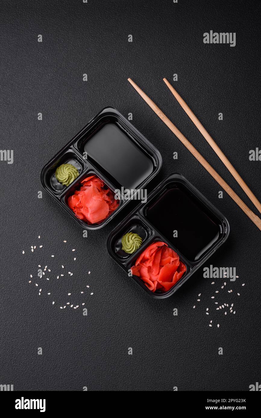 Pickled ginger, soy sauce and wasabi in portioned plastic containers on ...