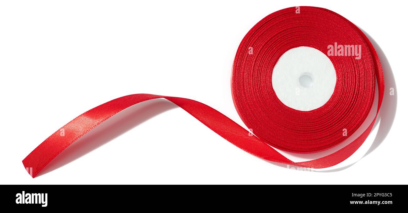 A spool with a red silk ribbon on a white isolated background, an ...