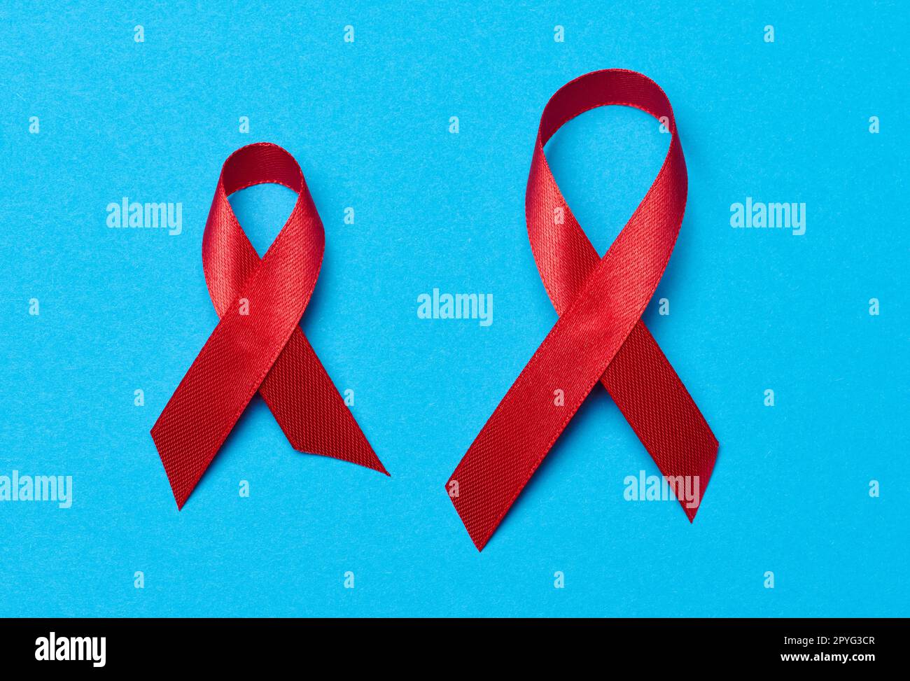 A silk red ribbon in the form of a bow on a blue background, a symbol ...