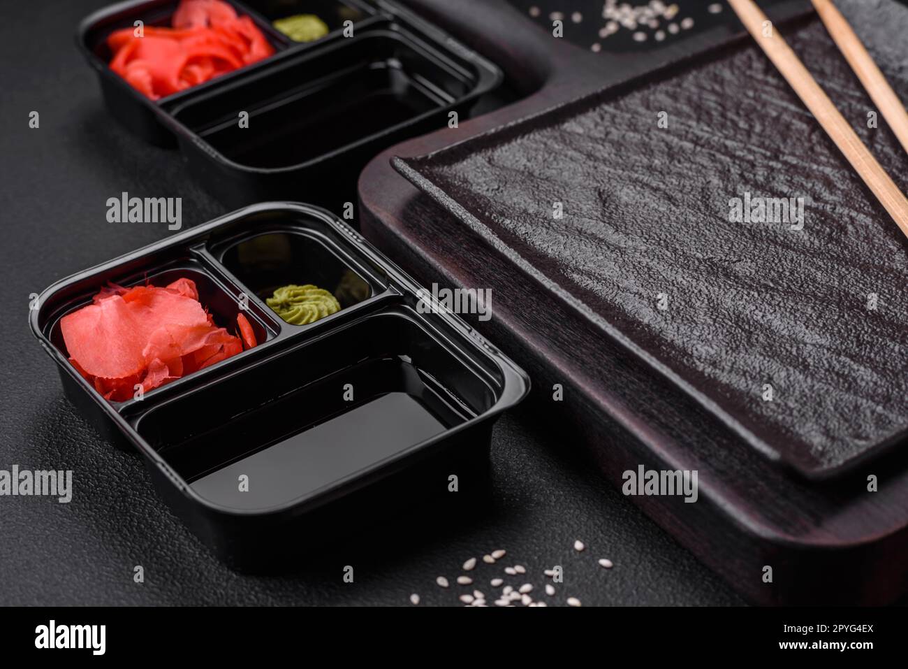 Pickled ginger, soy sauce and wasabi in portioned plastic containers on ...