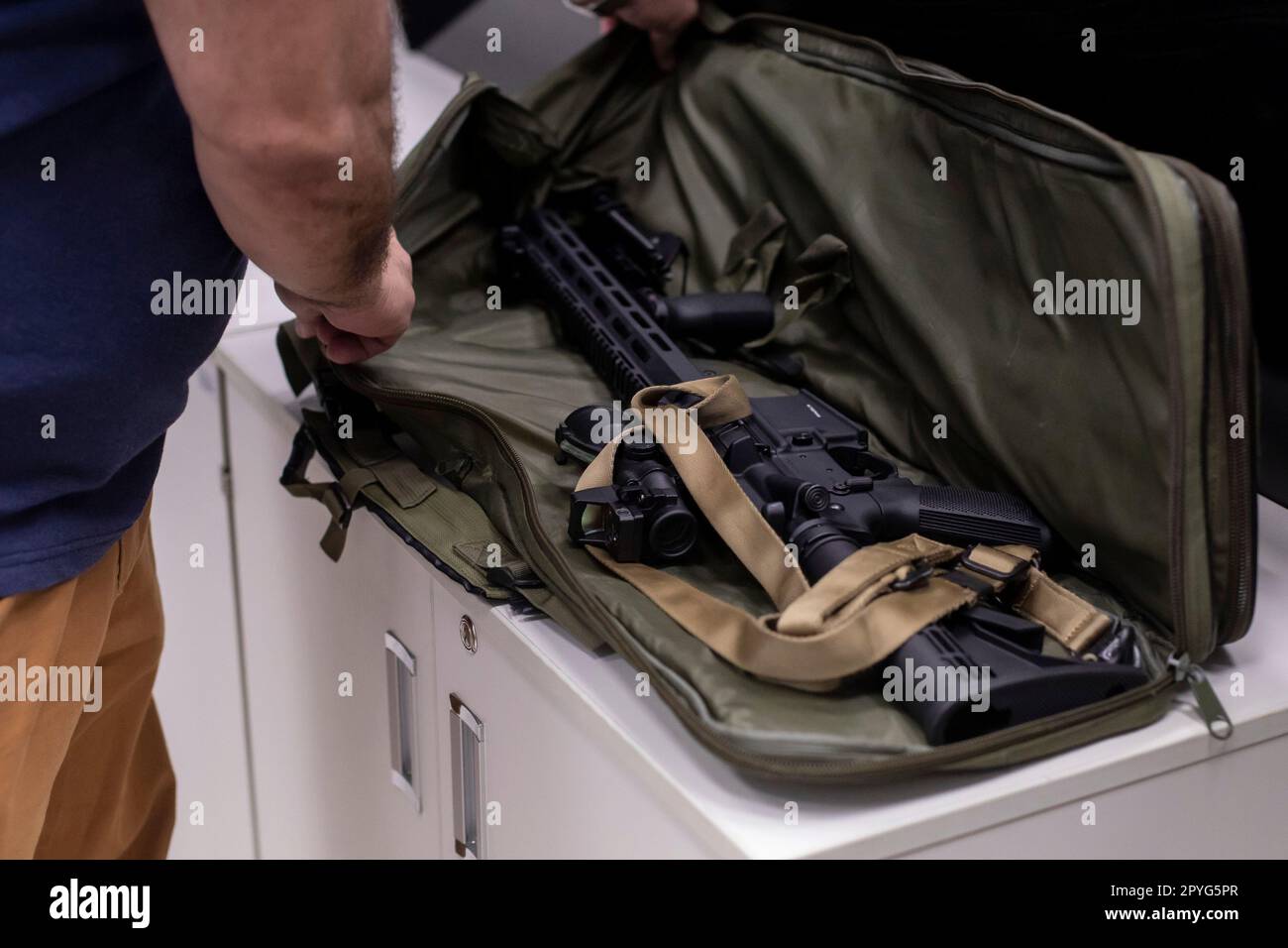 A gun owner brings in his weapon to register on the deadline given by ...