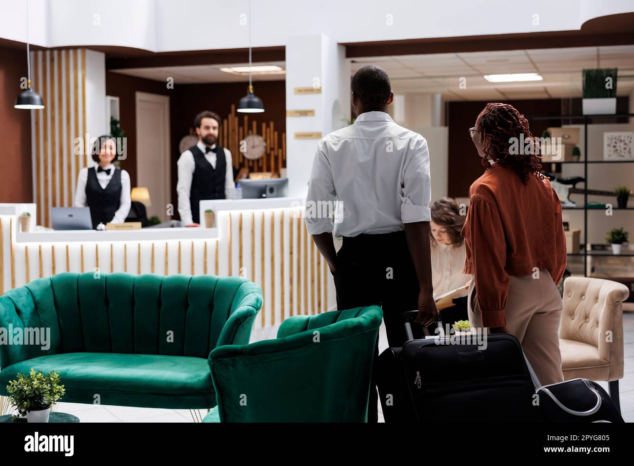 African american guests at front desk, arriving in hotel lobby and ...