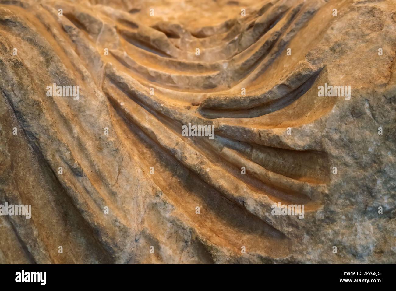 Background of ancient carved draped toga or robe in marble - selective ...