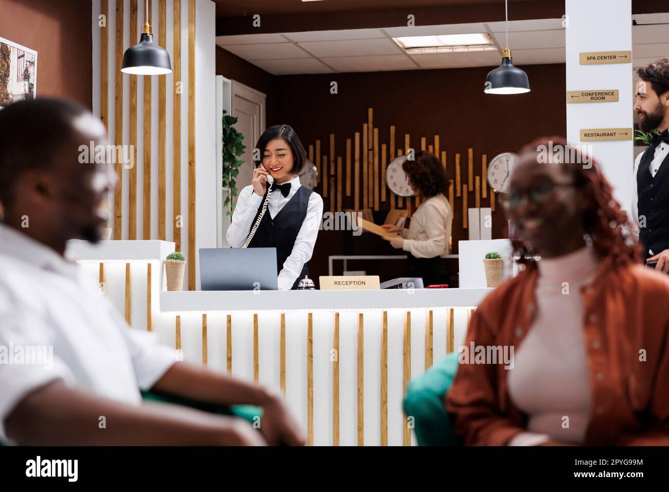 Woman making online booking on phone, talking on landline phone call to ...