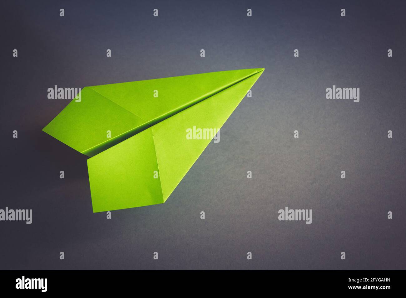 Green paper plane origami isolated on a blank grey background Stock ...