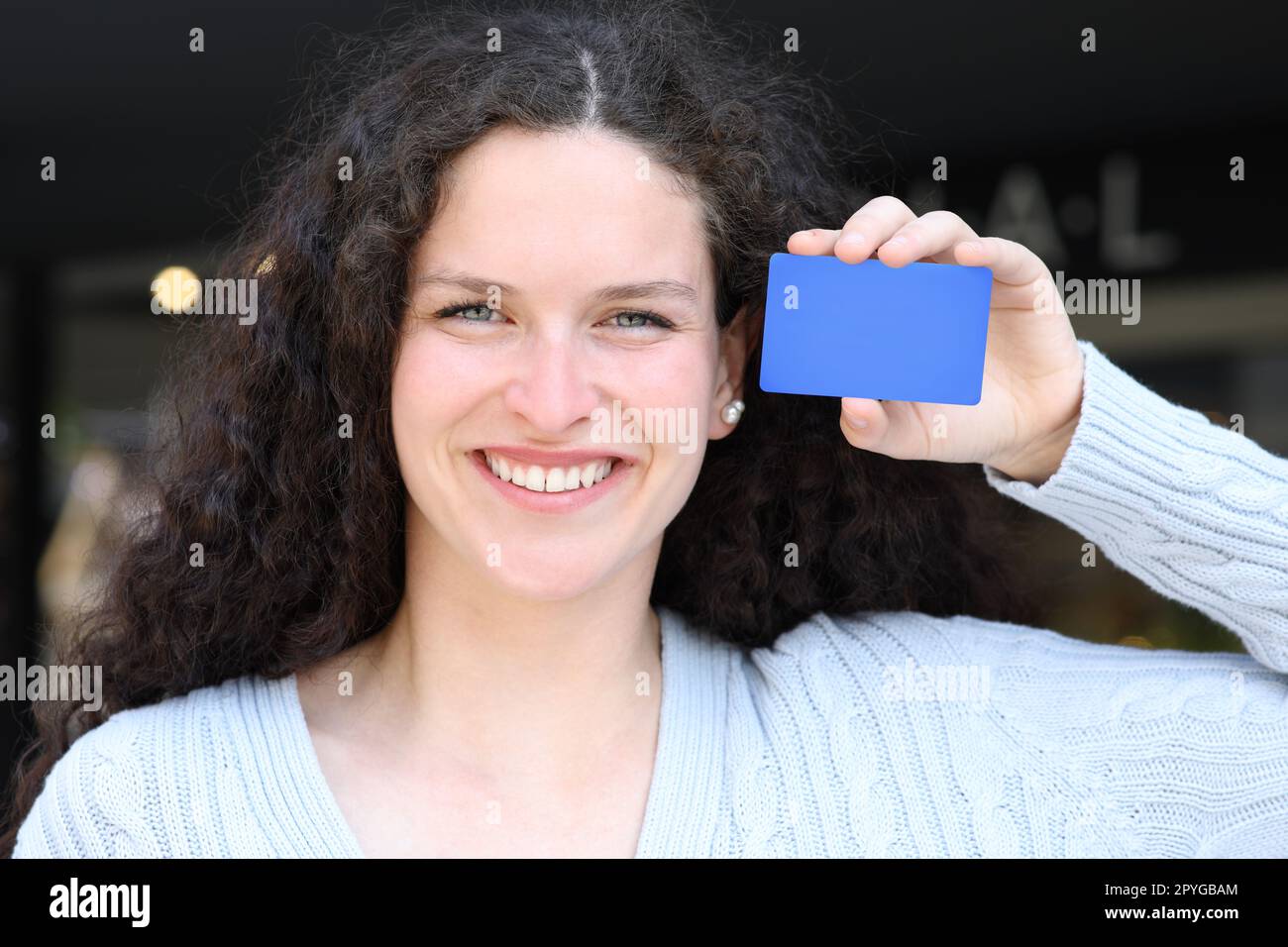Woman showing blank blue credit card in the street Stock Photo - Alamy