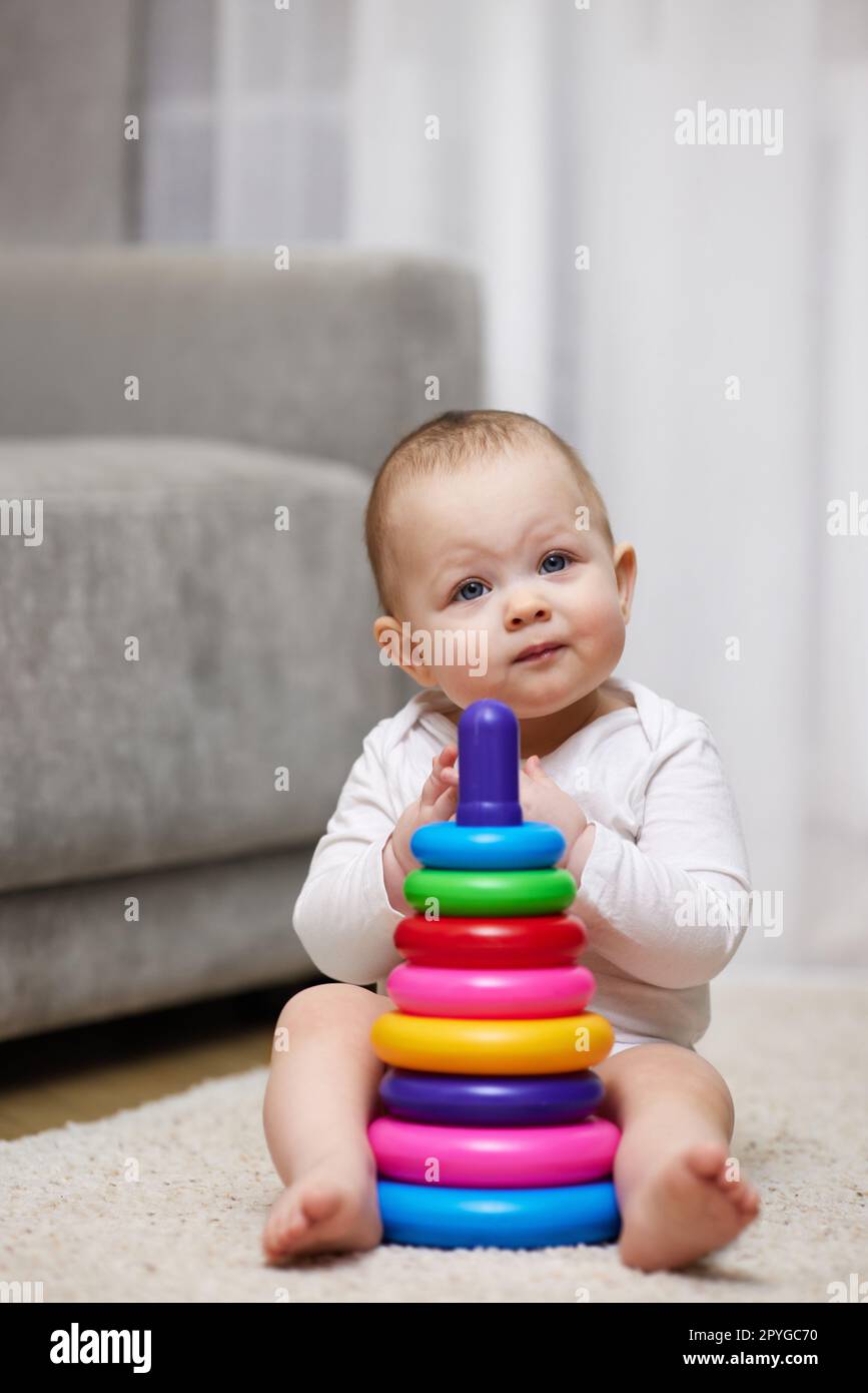 Cute baby girl playing with colorful toy pyramid Stock Photo - Alamy