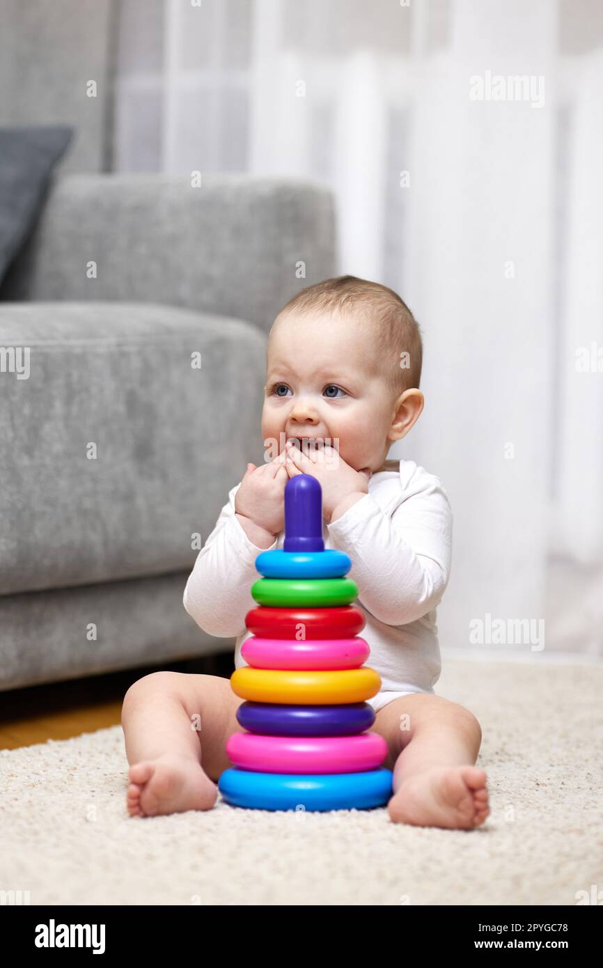 Cute baby girl playing with colorful toy pyramid Stock Photo - Alamy