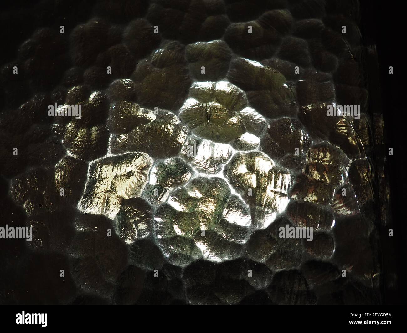 Corrugated glass, rear light source. Play of glare and reflections on a ...
