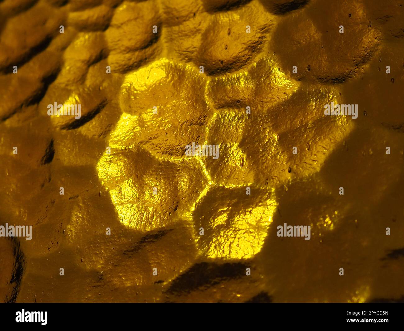 golden yellow corrugated glass with a light and dark background ...