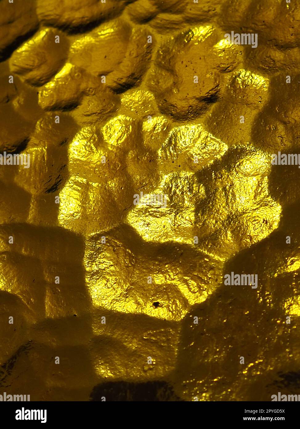 golden yellow corrugated glass with a light and dark background ...