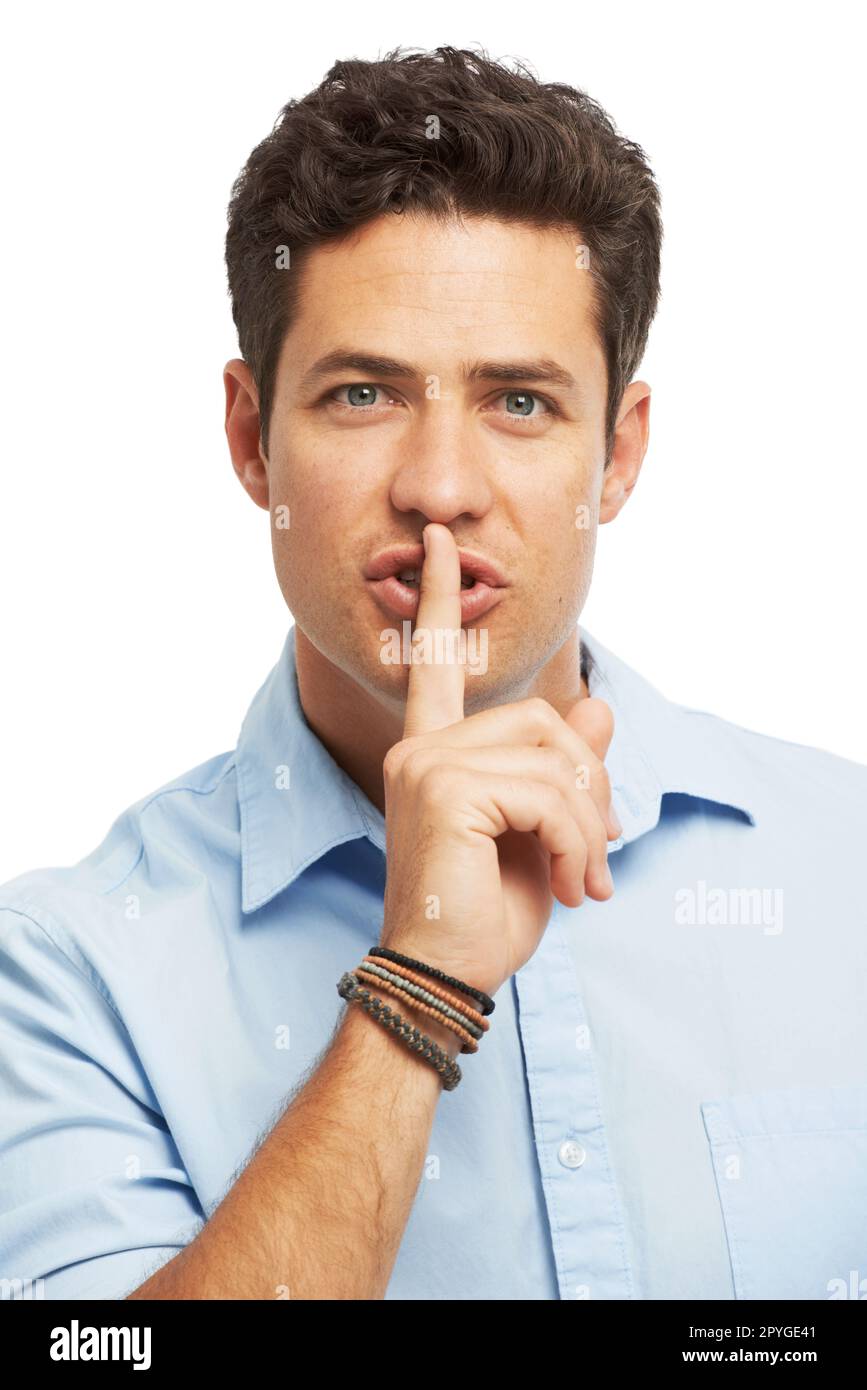 Keep quiet. A handsome young man with a finger to his lips isolated on ...