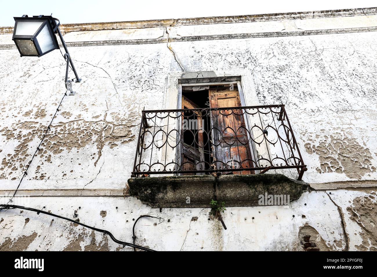 Facade with damaged forged iron balcony and vintage streetlight Stock ...