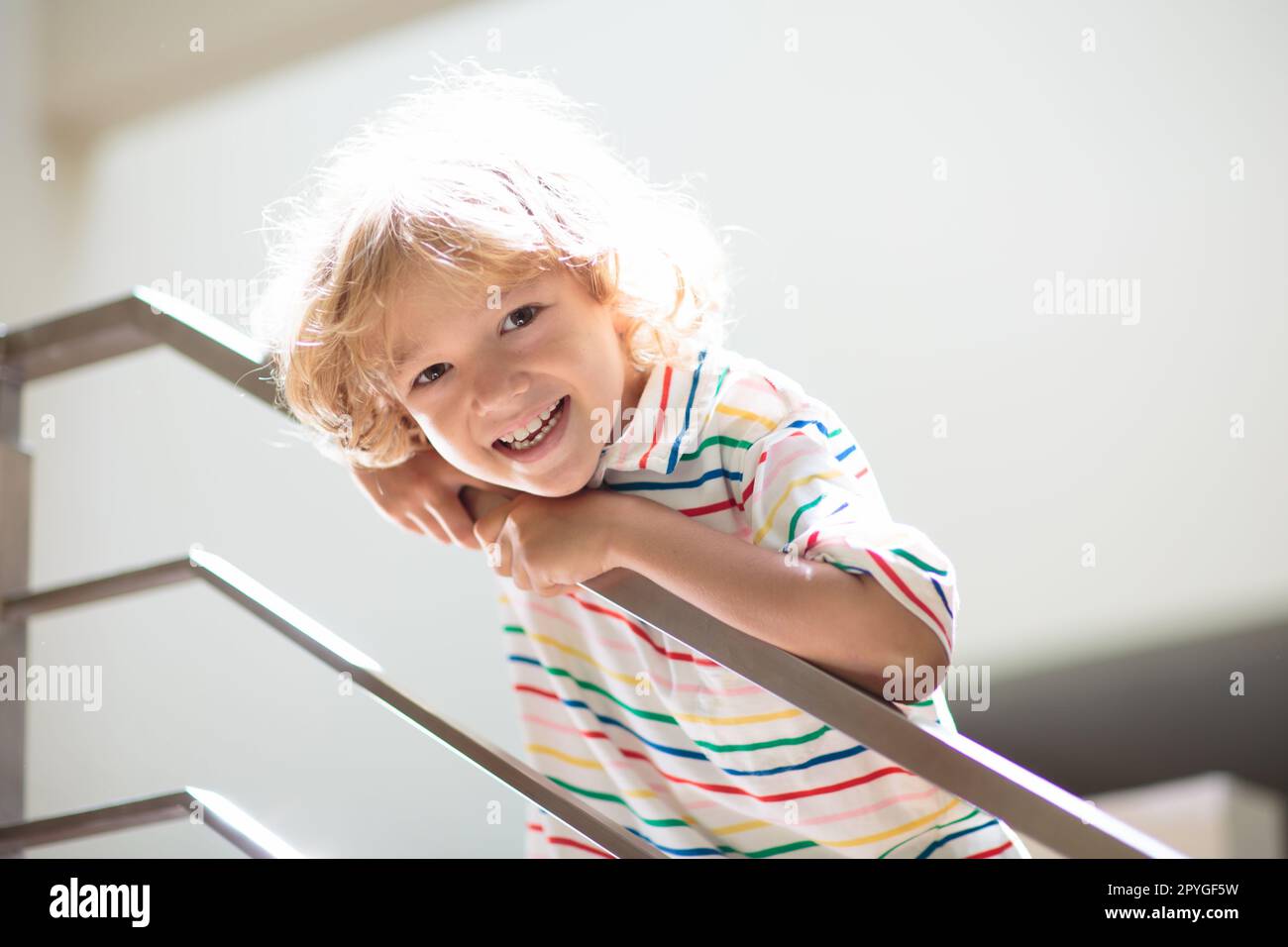 Little boy on stairs. Sunny staircase in new family home. Child ...