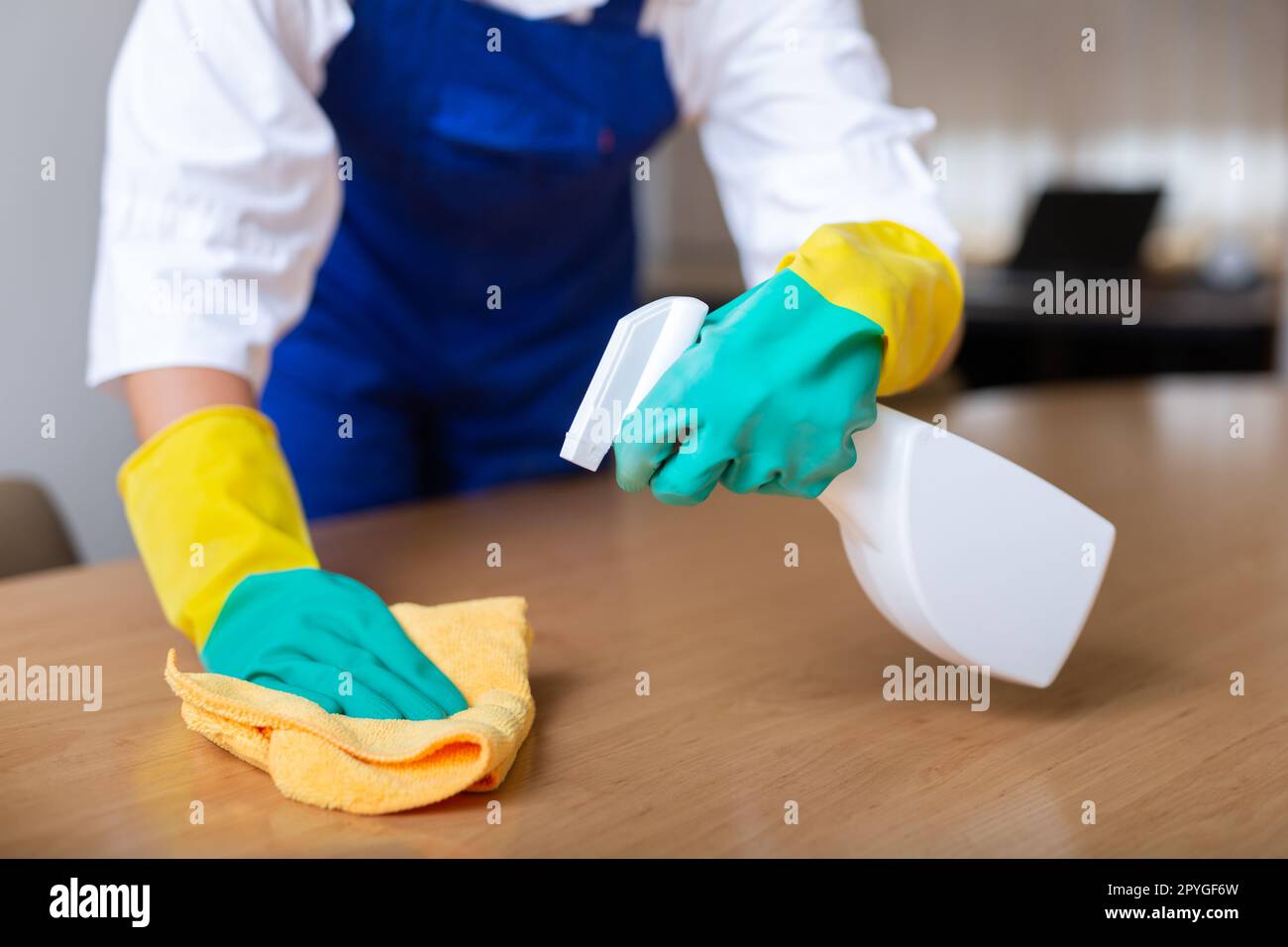 Worker cleaning table with rag and detergent Stock Photo - Alamy