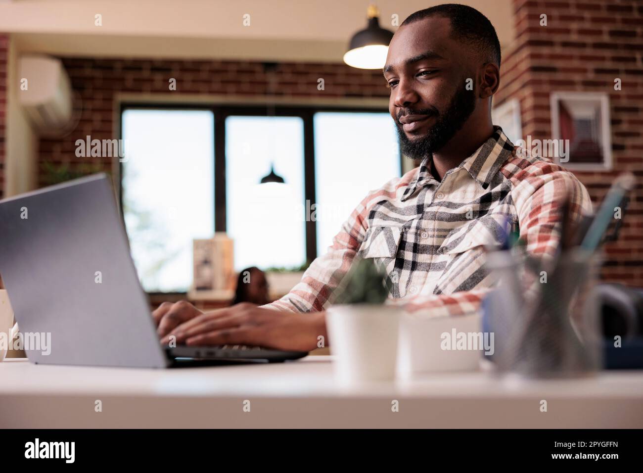 Portrait of african american freelancer working remote typing and ...