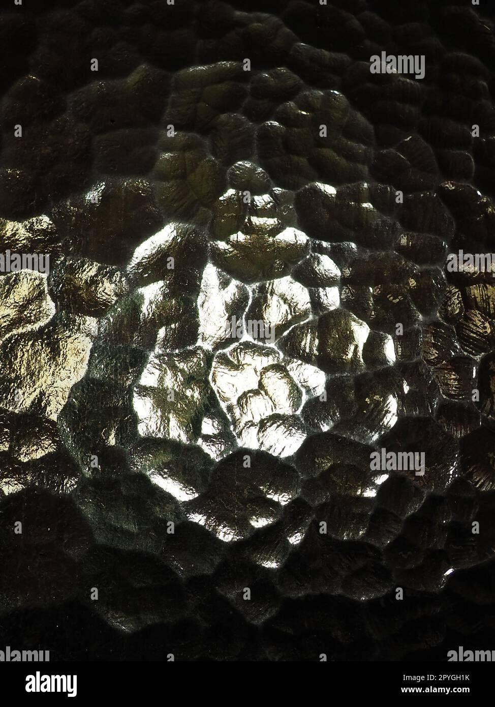 Corrugated glass, rear light source. Play of glare and reflections on a ...