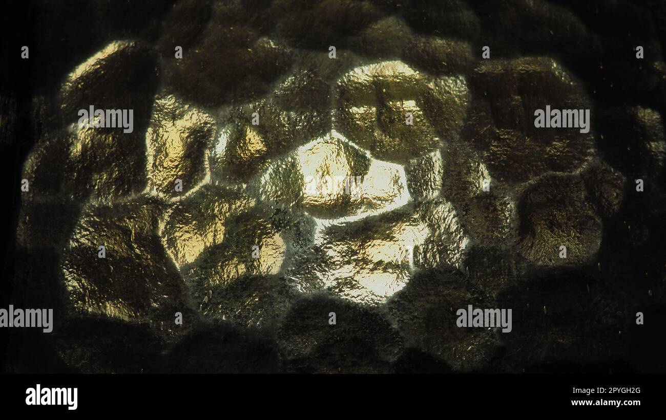 Corrugated glass, rear light source. Play of glare and reflections on a ...