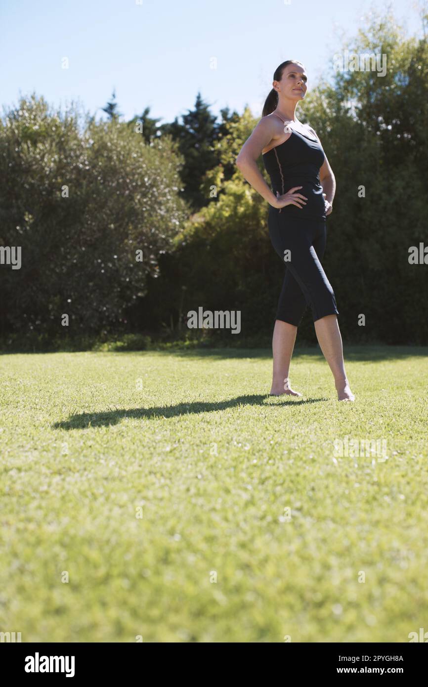 Gentle garden stretching. An attractive brunette standing and ...