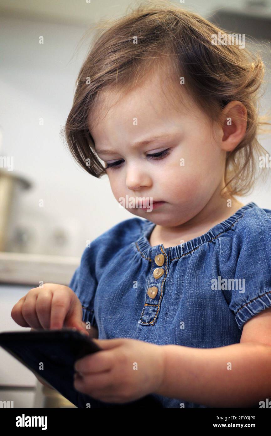 Cute little girl 1.5-2.5 is typing something or dials a number on a ...