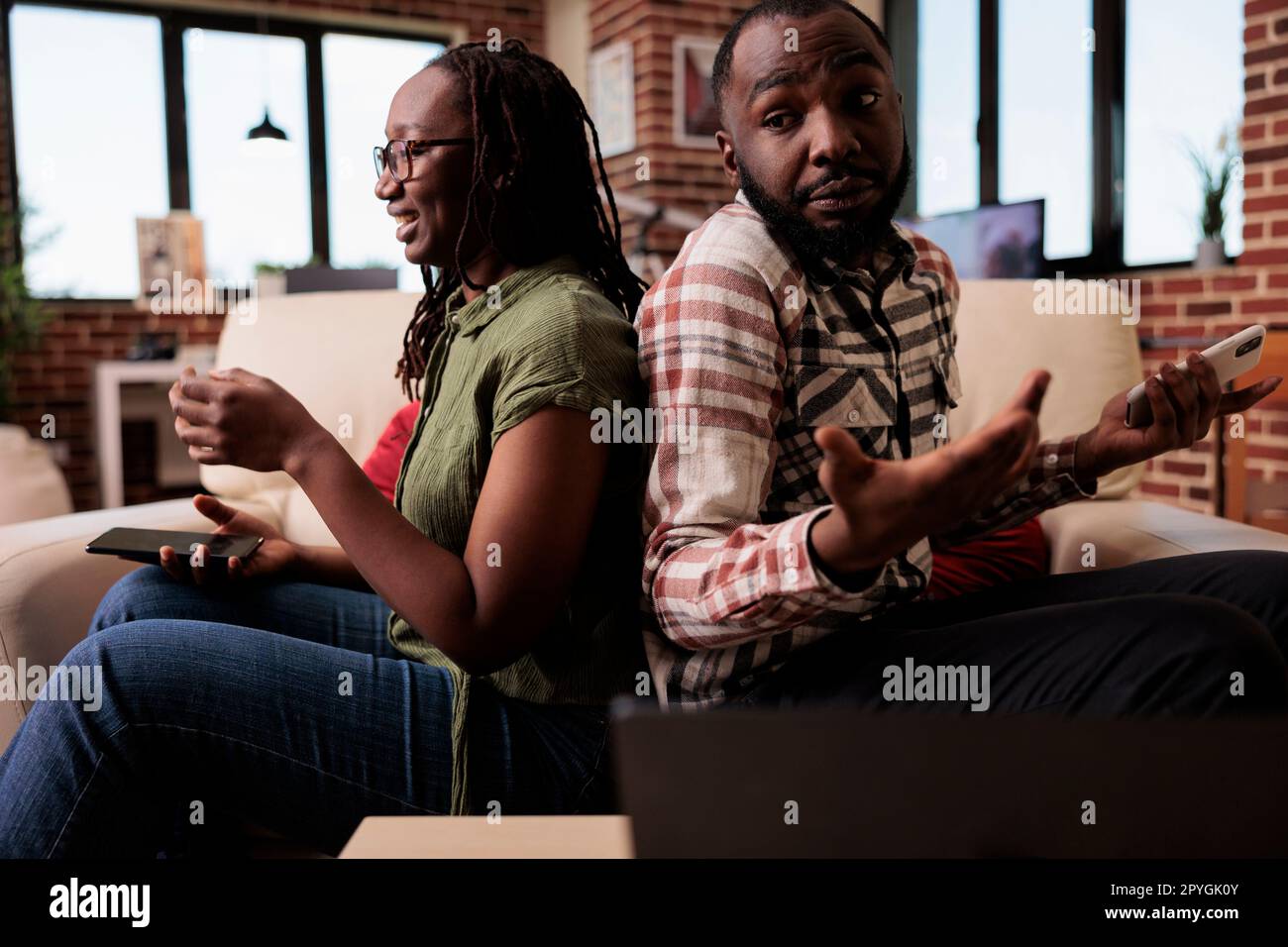 Confused boyfriend arguing with woman about contents of smartphone ...