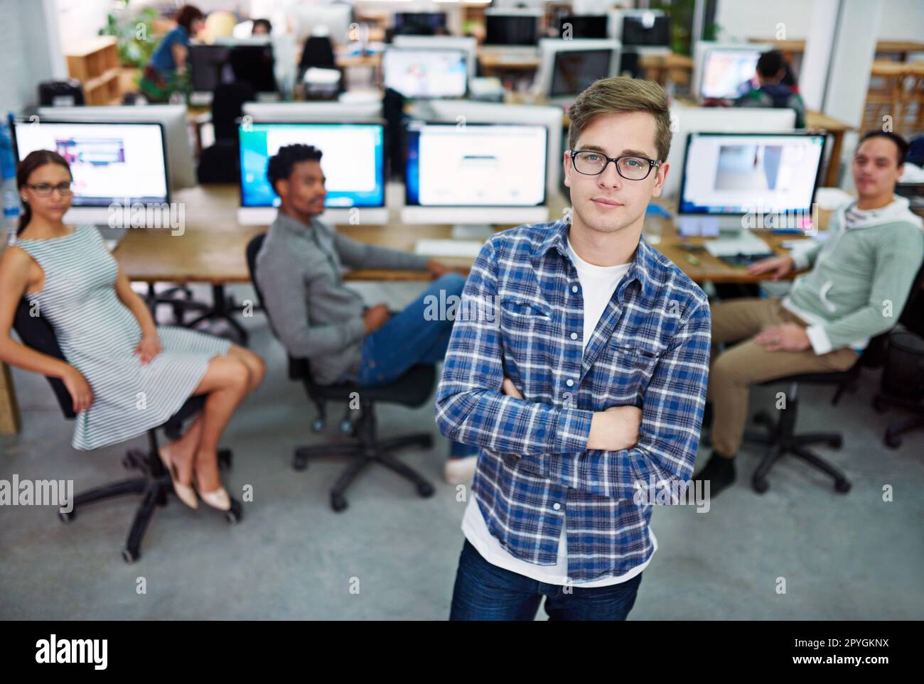 Professionals at work. Portrait of a young man standing in an office ...