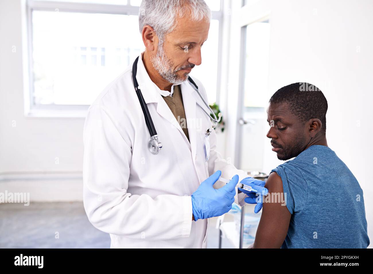 Doctor giving injection male patient hi-res stock photography and ...
