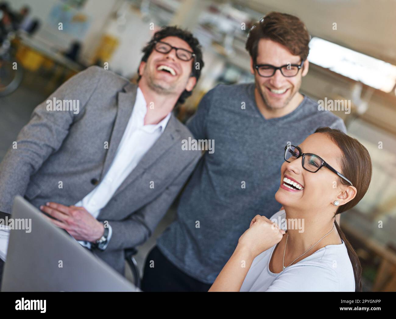 Success keeps them upbeat. laughing colleagues working together on a ...