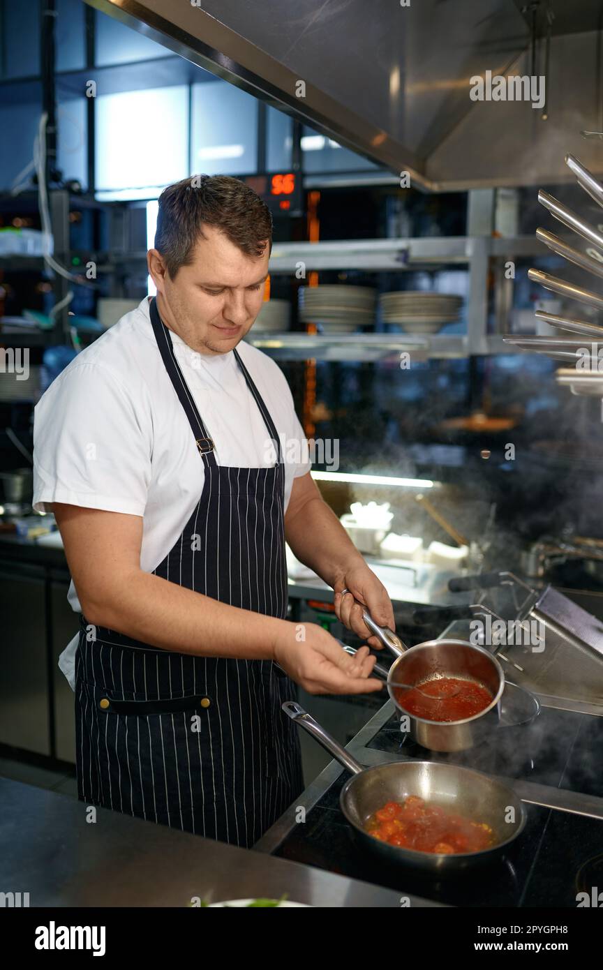 Master chef preparing tomato sauce for pasta in frying pan Stock Photo ...
