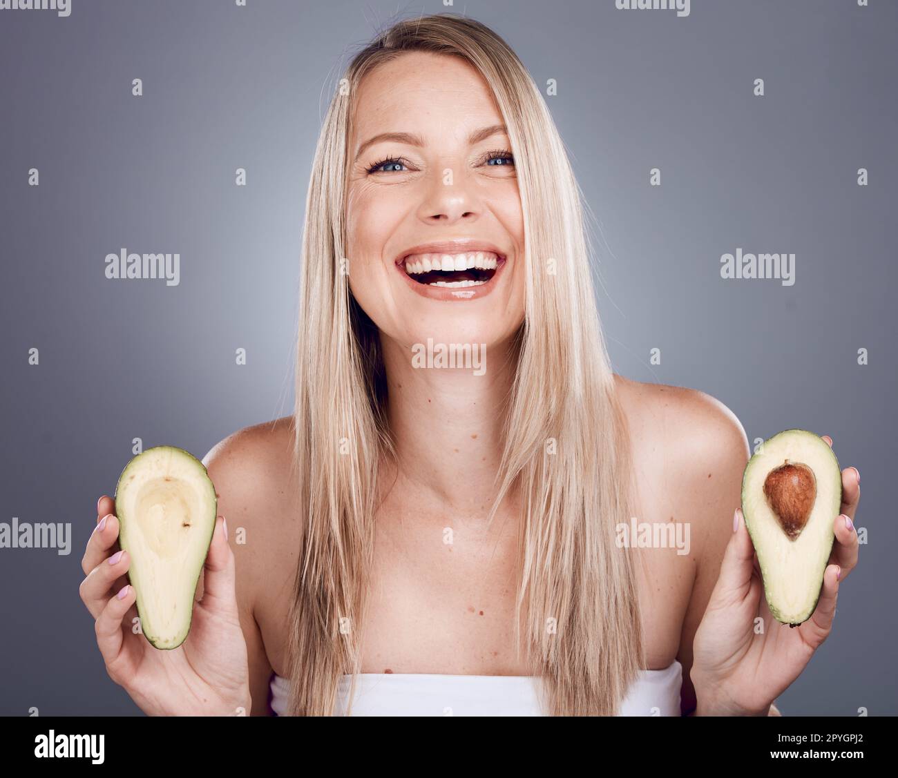 Portrait, beauty and avocado with a model woman in studio on a gray ...