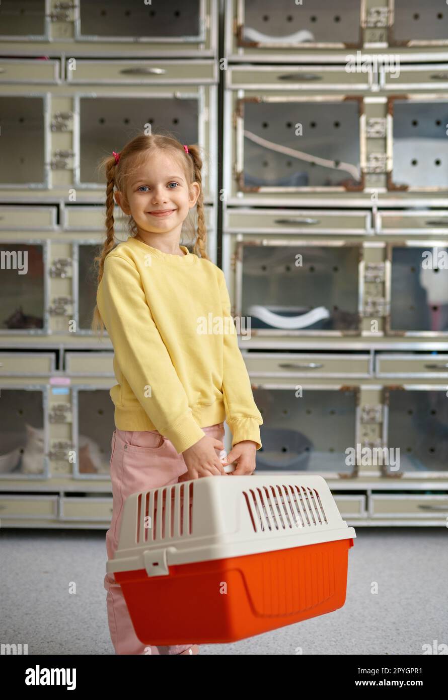 Portrait of little girl holding cage with new pet bought at veterinary ...