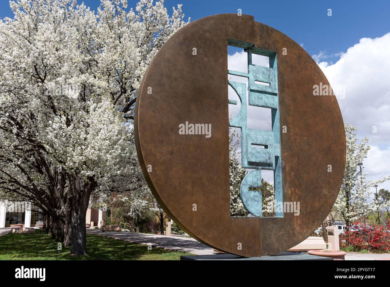 Round bronze sculpture, 10-feet tall, by Dan Naminga, next to white ...