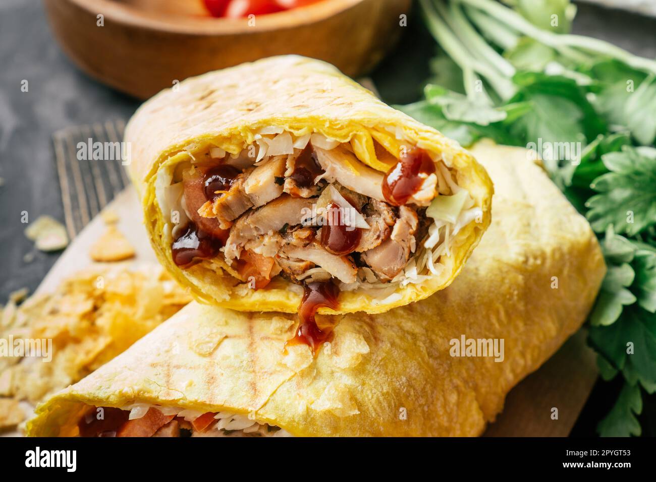 Crispy shawarma with chips, barbeque sauce, chicken in pita bread on ...