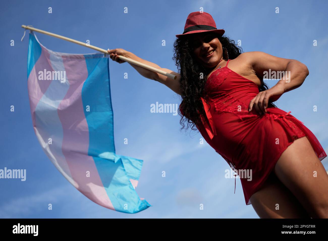A demonstrator on stilts waves a Transgender flag during a march to ...