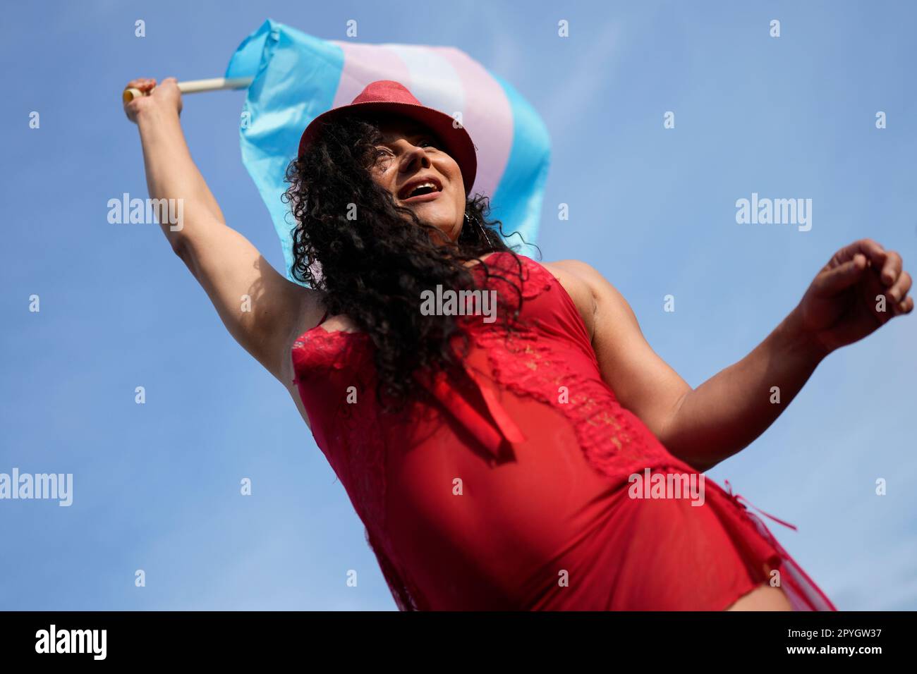 A demonstrator on stilts waves a Transgender flag during a march to ...