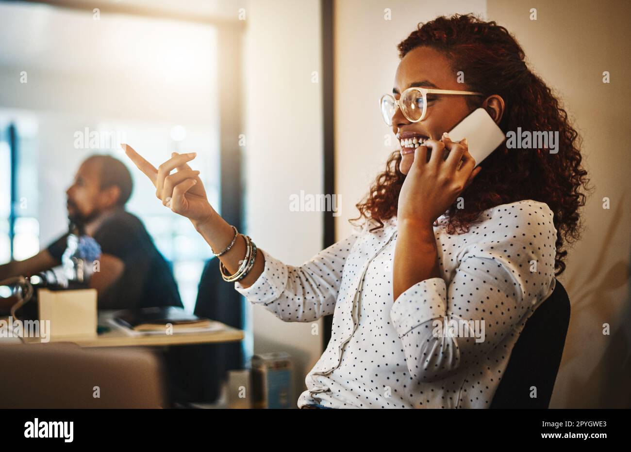 Talking business right through the night. a young businesswoman using a ...