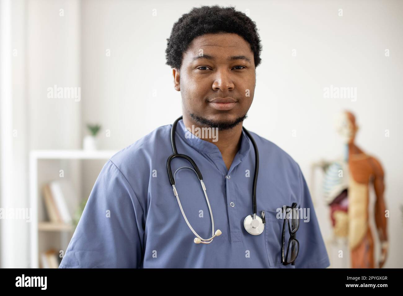Portrait of attractive multicultural man in blue scrubs and stethoscope ...