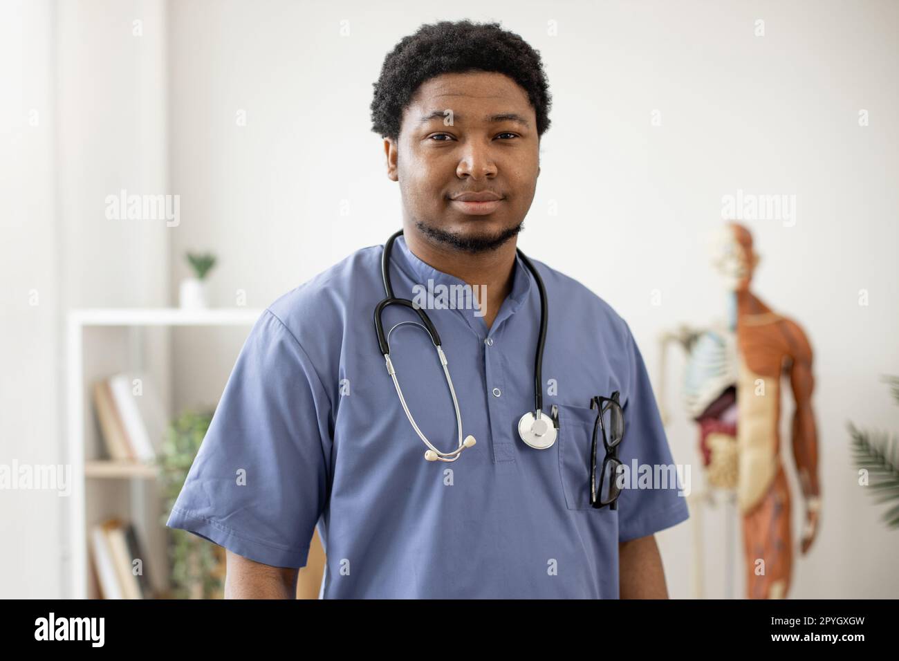 Portrait of attractive multicultural man in blue scrubs and stethoscope ...