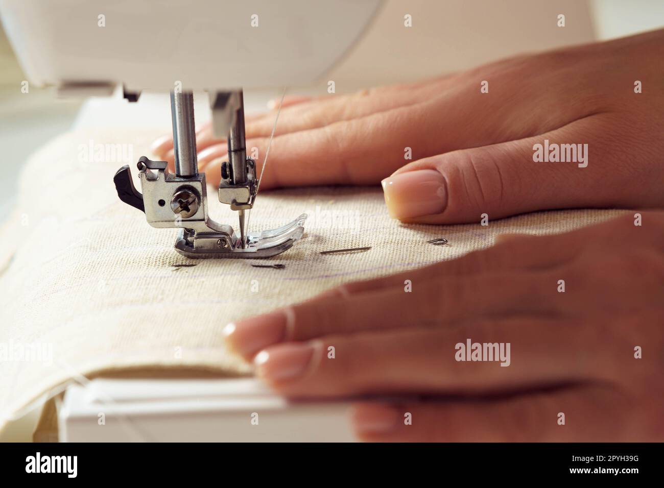 Cropped female dressmaker hands putting white soft fabric textile with ...