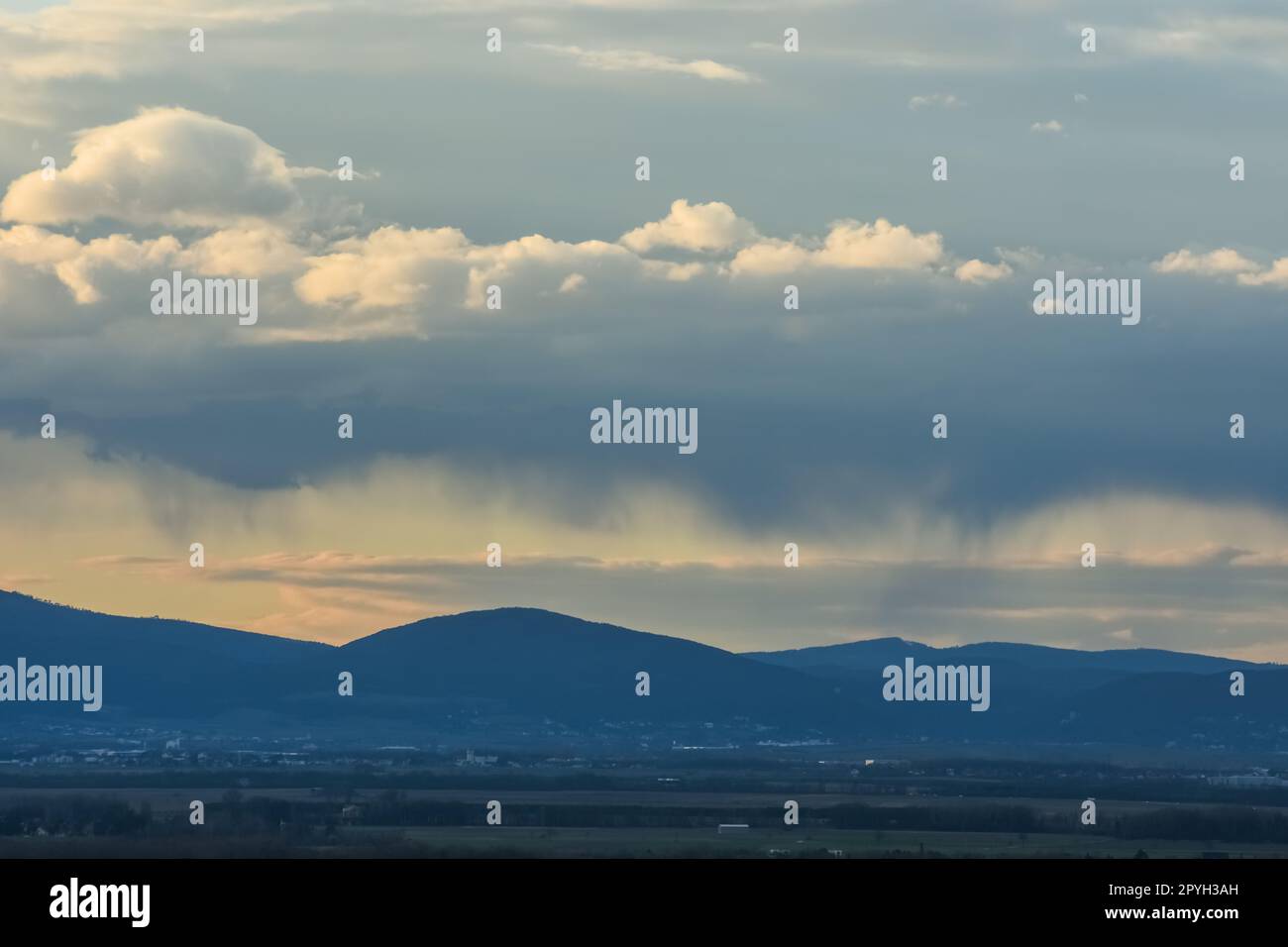 rain under clouds over a landscape with mountains Stock Photo - Alamy