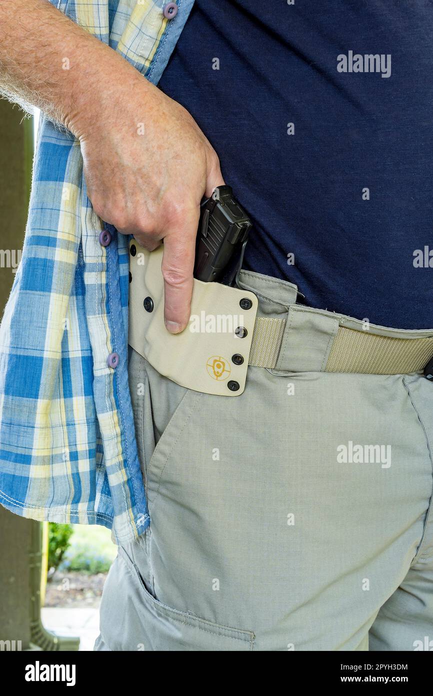Man drawing a Sig Sauer 9mm pistol or handgun from an outside the ...