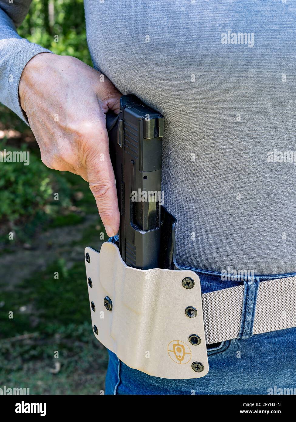 Woman drawing a Sig Sauer 9mm pistol or handgun from an outside the ...