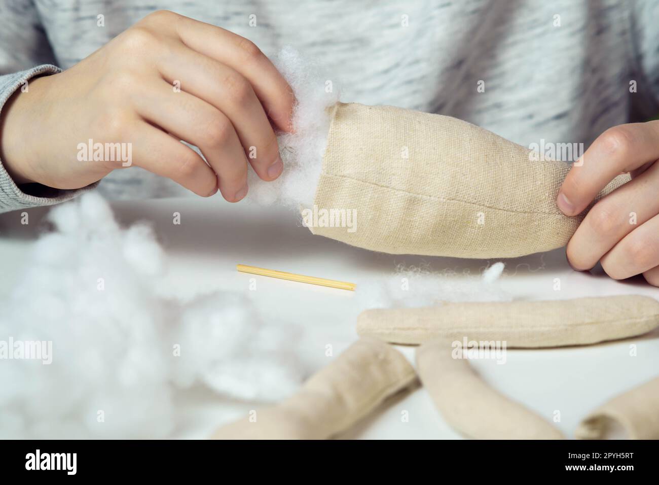 Unrecognizable closeup woman designer hands sew soft toy. Create paws ...