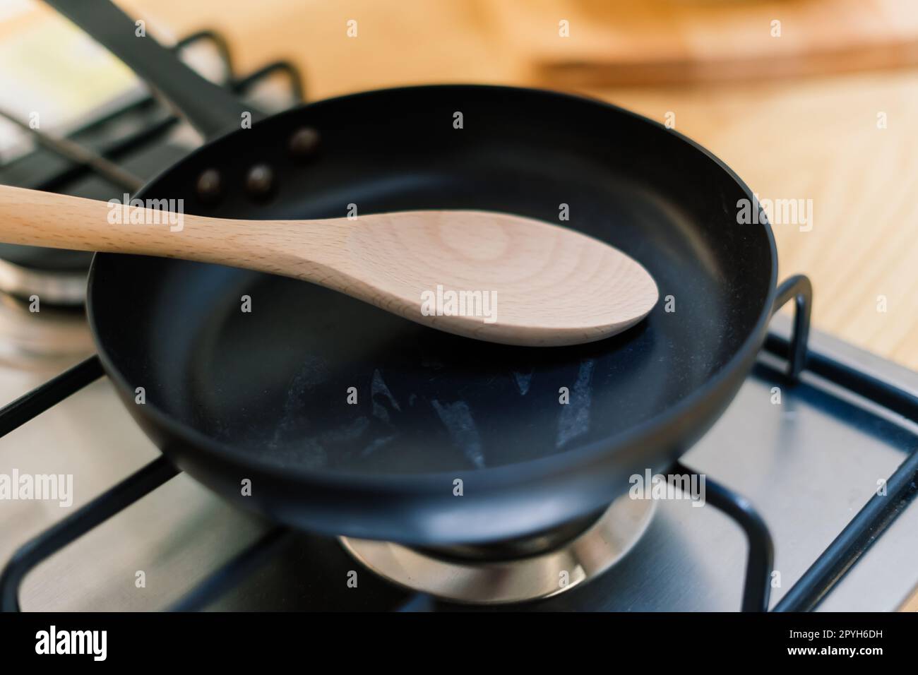 Spatula in skillet teflon coating pan on gas stove against spoon ...