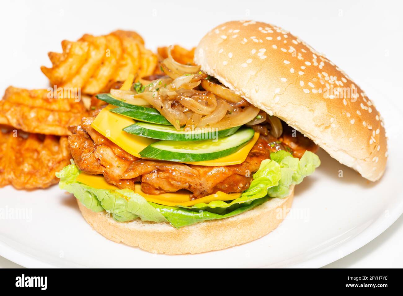 Oven baked chicken burger with criss cross fries on white plate Stock ...