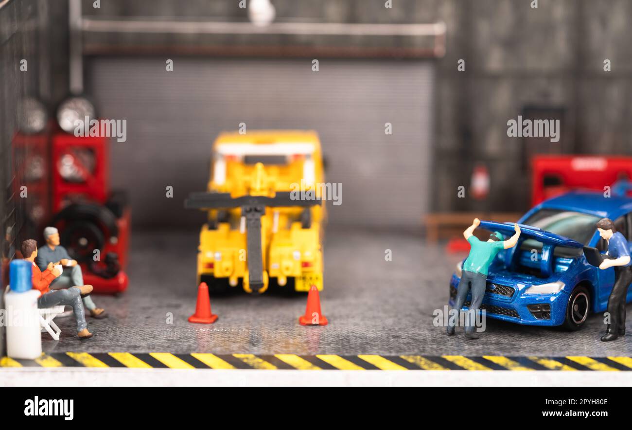 Miniature customers sitting and waiting while the mechanic checking on ...