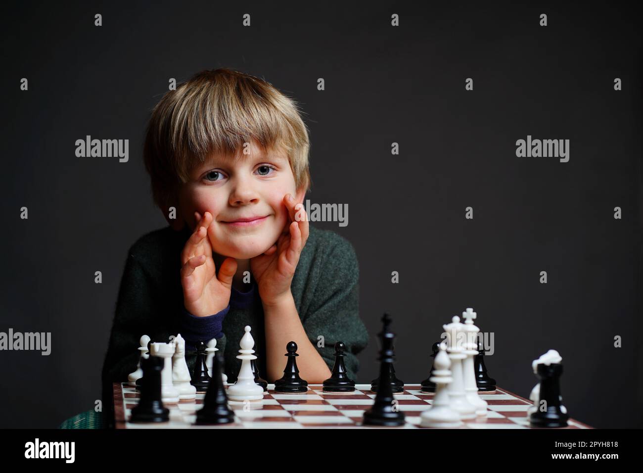Portrait of cute blond child with chess, playing board game, little boy ...