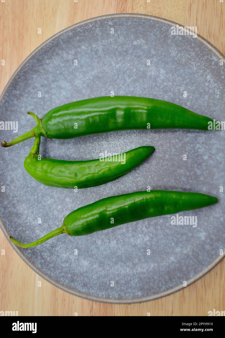 Green cayenne chilies against a plain background Stock Photo - Alamy